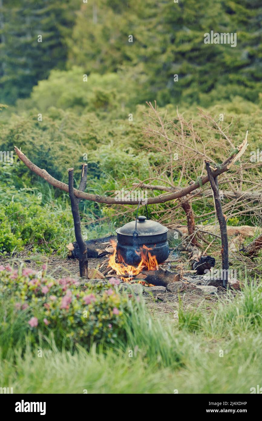 Cooking in field conditions, boiling pot at the campfire on picnic ...