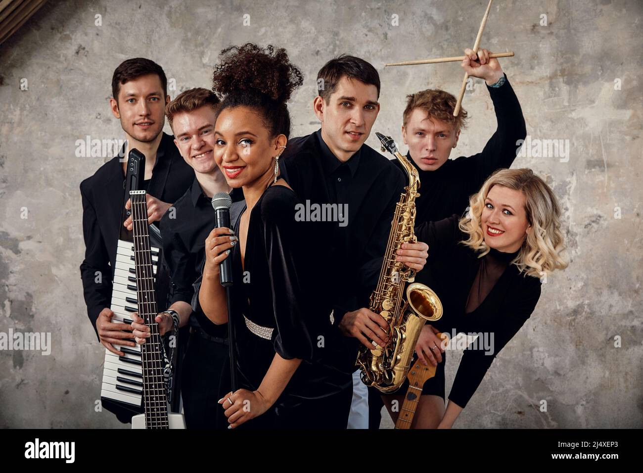 Portrait of diverse group of young people musical band playing with ...