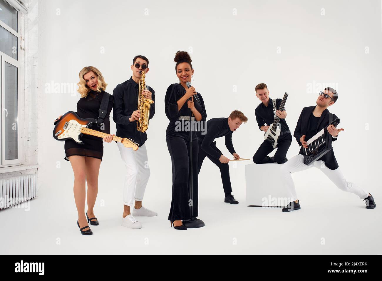 Portrait of diverse group of young people musical band playing with ...