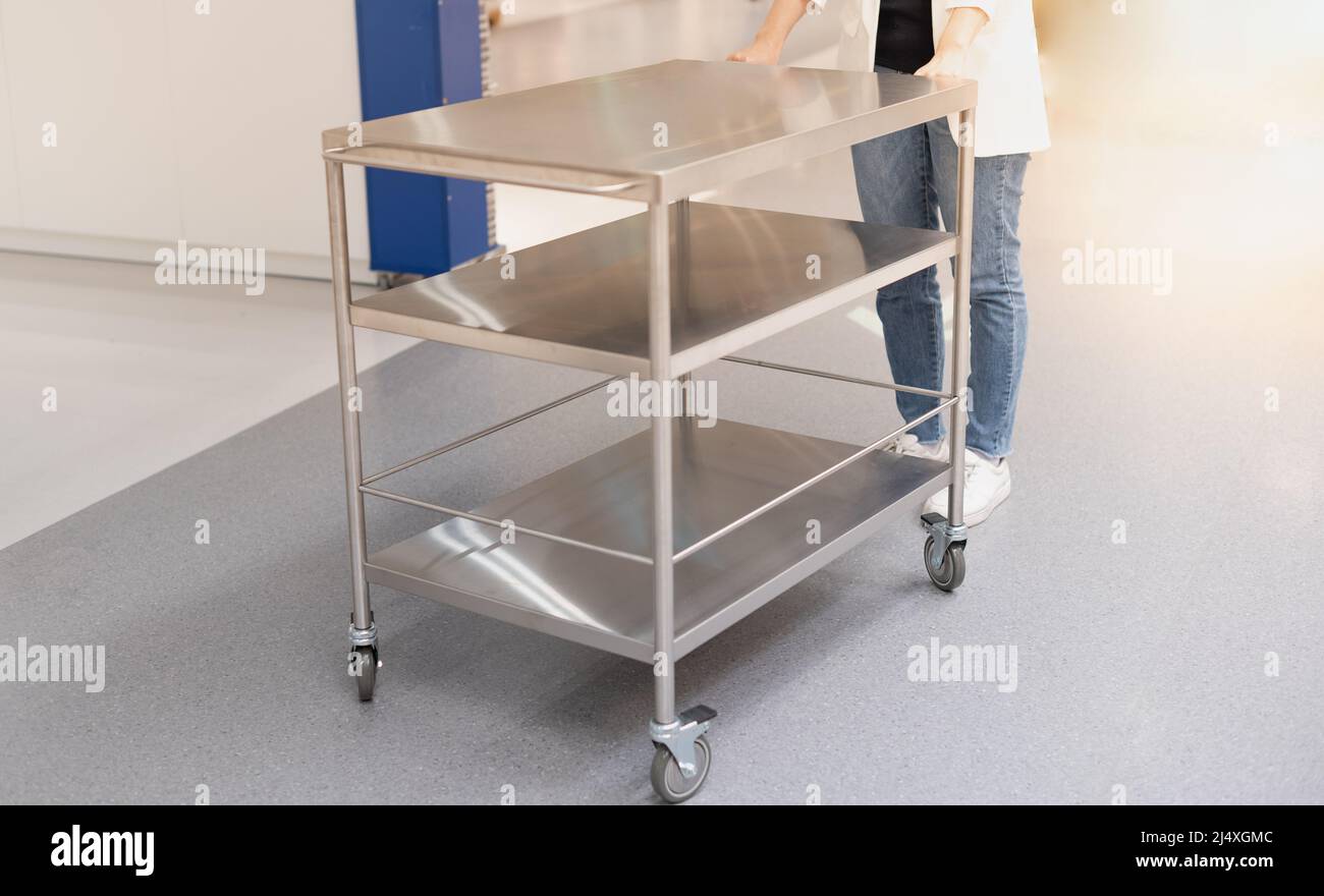 Female hand pushing the stainless steel food trolley cart to move a lot ...