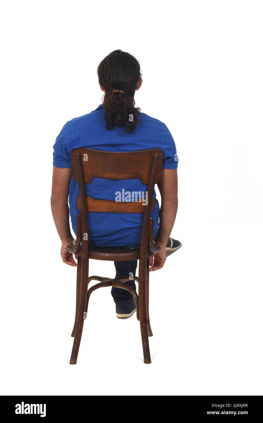 rear view of a man with ponytail, legs crossed on white background ...