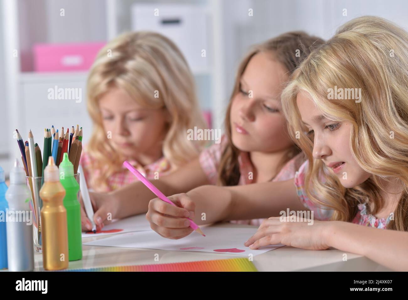 Beautiful girls drawing with pencils at desk Stock Photo - Alamy