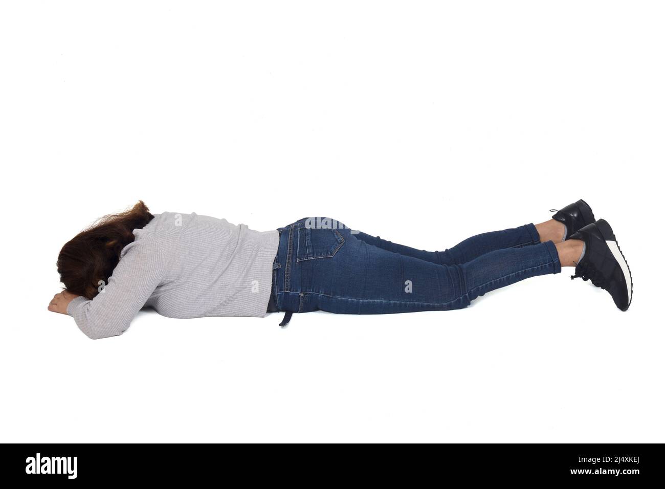 rear view of a woman lying on the floor face down on white background ...