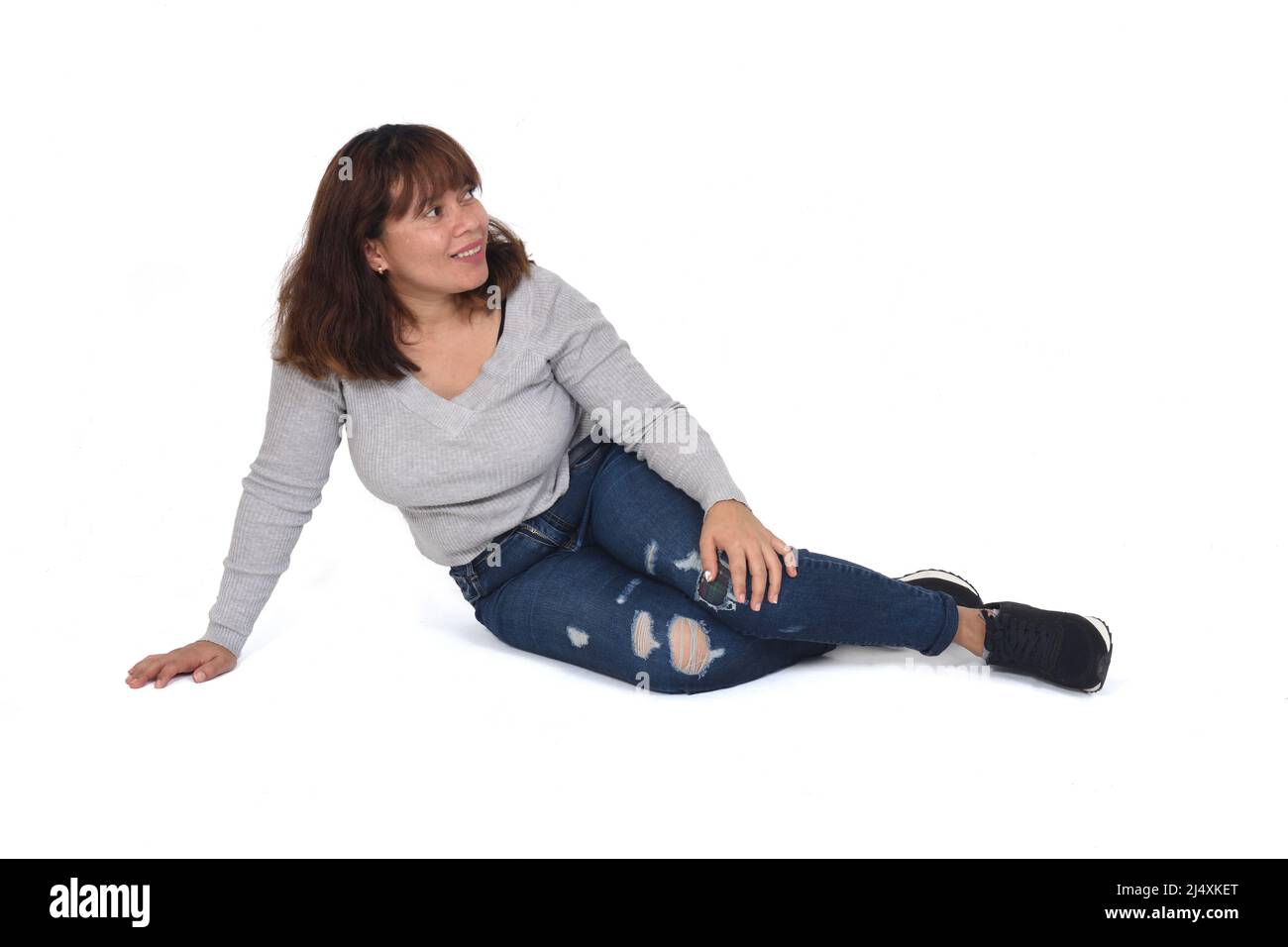 side view of woman sitting on the floor white background Stock Photo ...