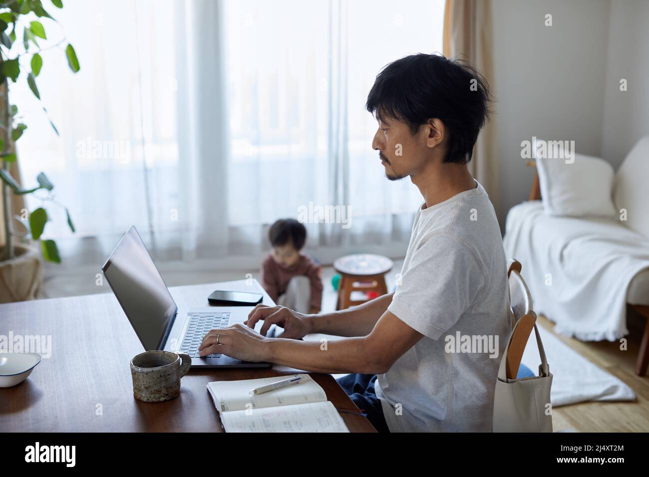 Japanese man working from home with kid Stock Photo - Alamy