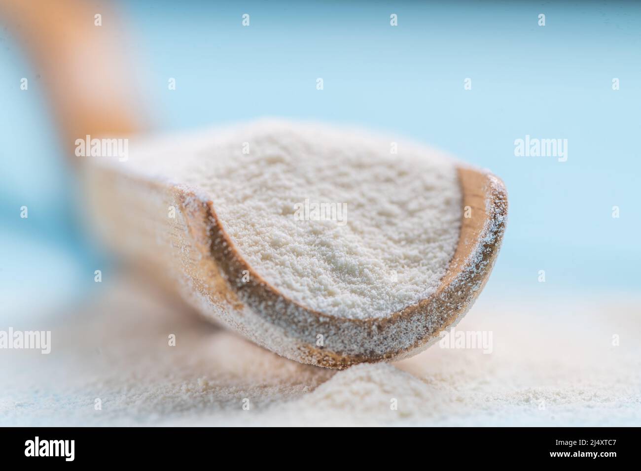 Collagen powder in spoon on wooden blue background Stock Photo - Alamy