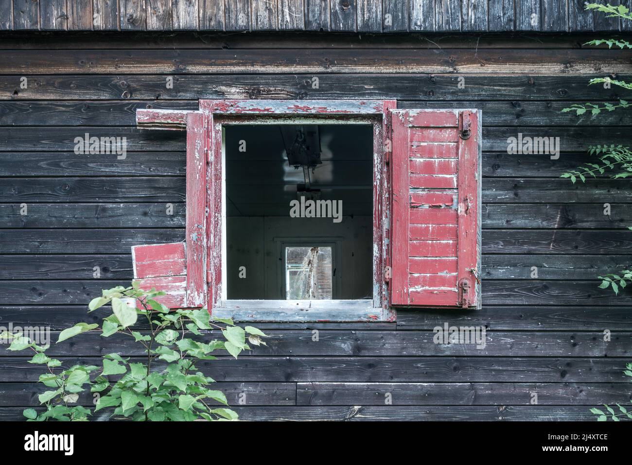 Detail of a broken window of old abandoned wooden house. Red window ...