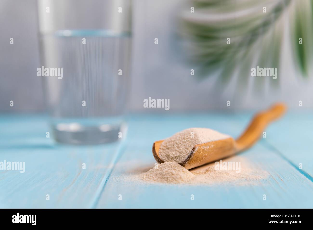 Collagen powder in spoon on wooden blue background Stock Photo - Alamy