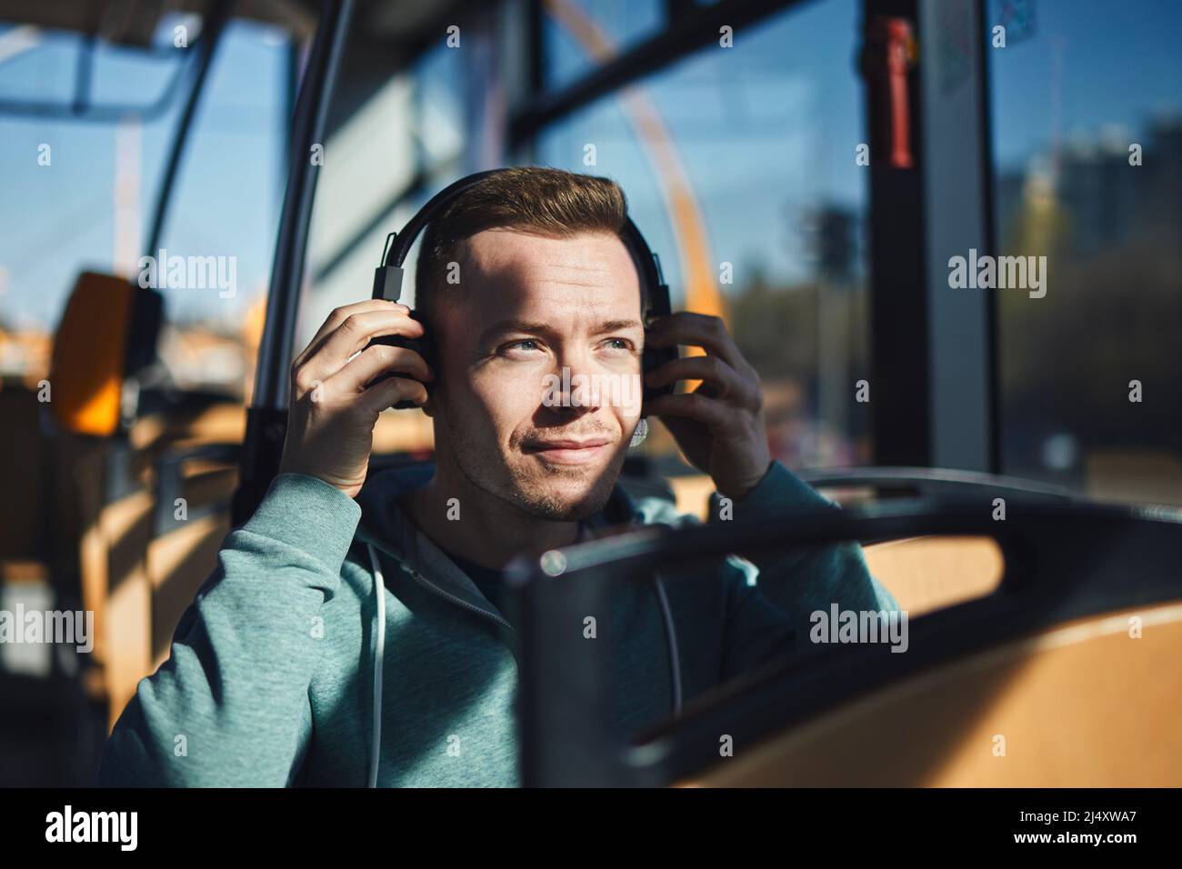 Man listening music in wireless headphones while commuting by public transportation Stock Photo ...