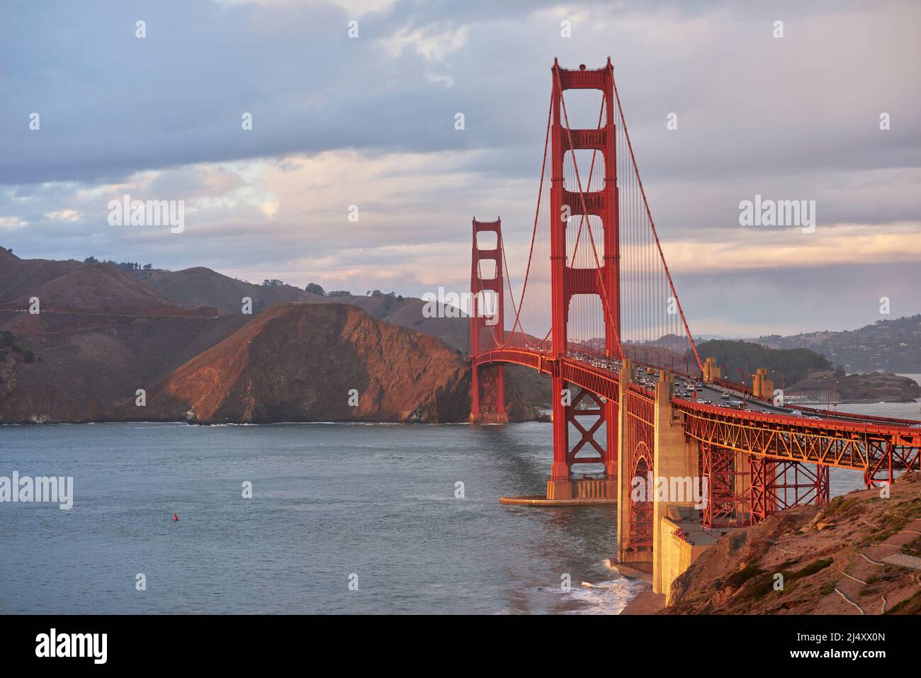 Wide angle view of Golden Gate Bridge against stormy sky at sunset ...