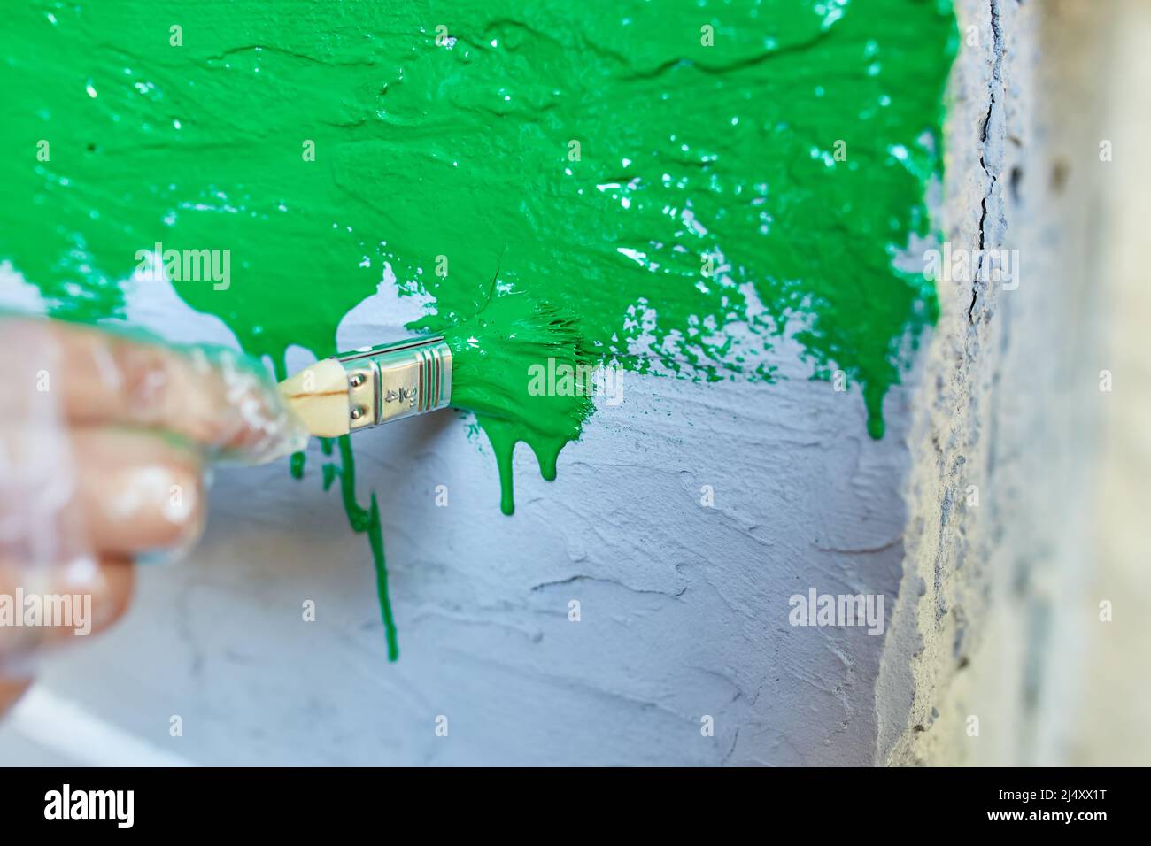 brush in hand paints a bench in bright colors, painting a garden bench ...