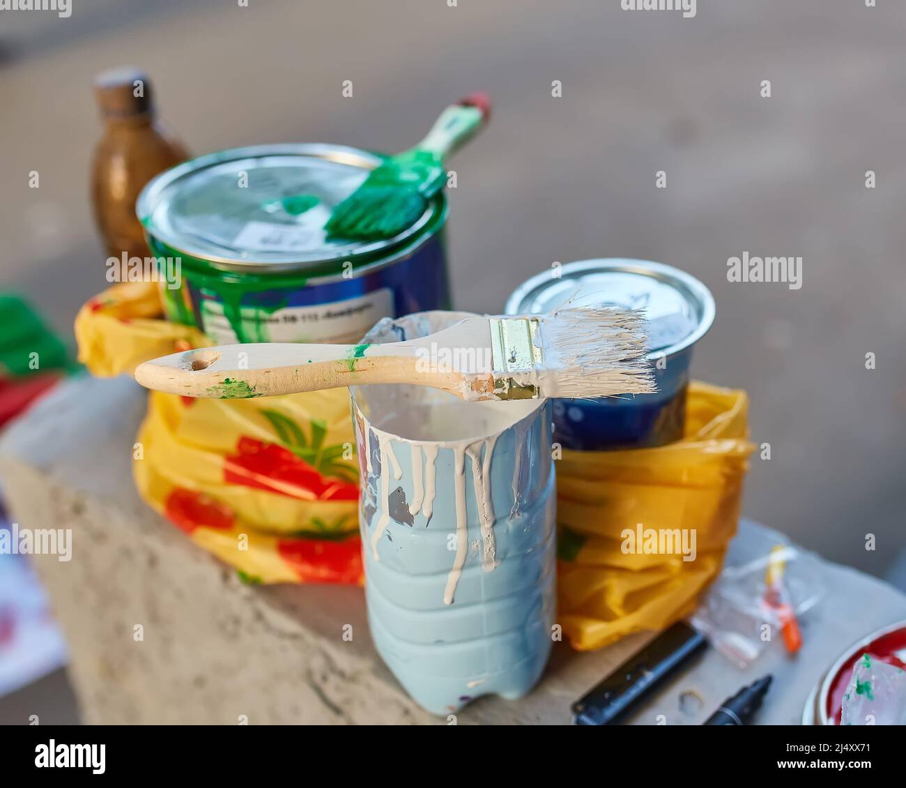 brush in hand paints a bench in bright colors, painting a garden bench ...