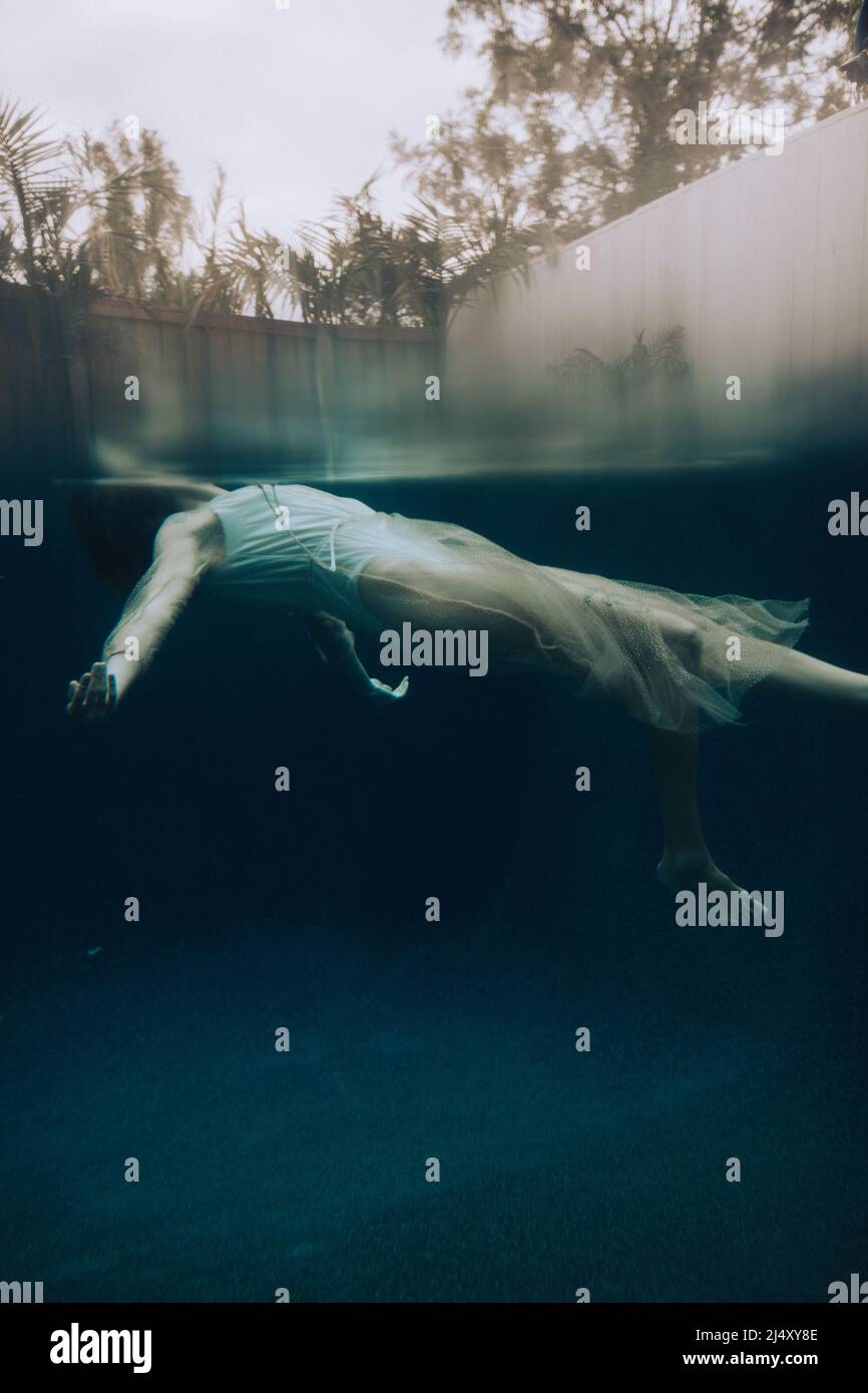 Woman body floating underwater in a care free vibe wearing dress Stock ...