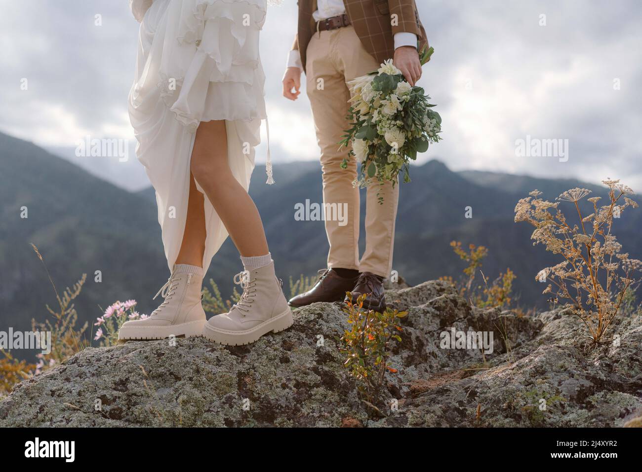 Legs of the bride and groom in wedding dresses Stock Photo - Alamy