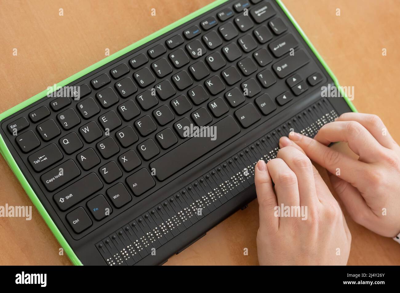 A blind woman uses a computer with a Braille display and a computer ...