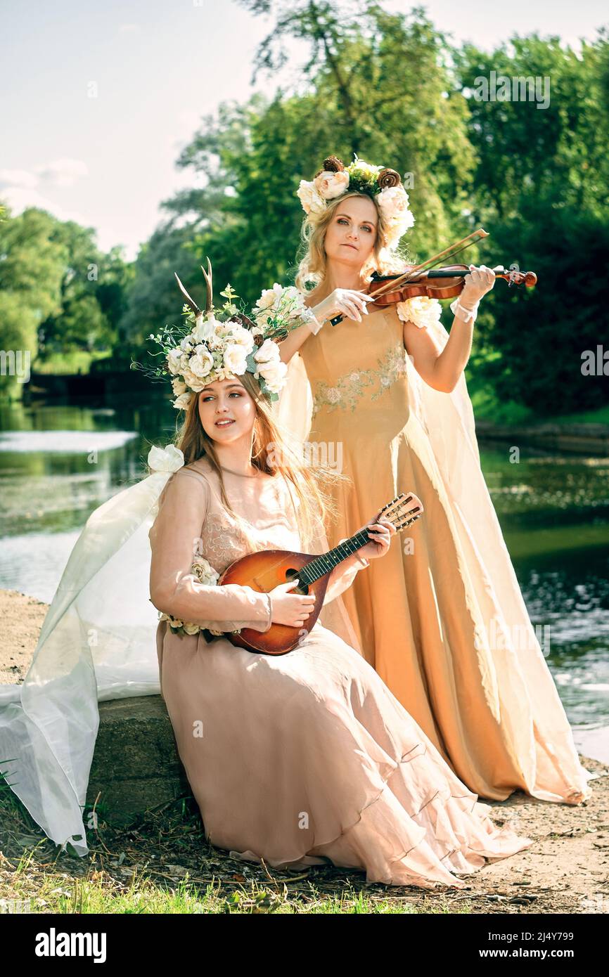 duet of women playing guitar and violin in nature Stock Photo - Alamy