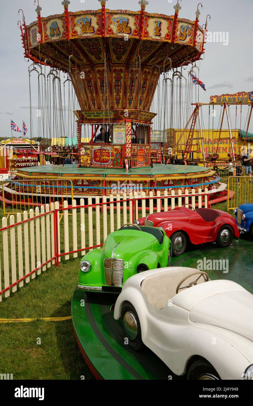 A fairground ride for children. Small "cars" to steer and pretend to ...