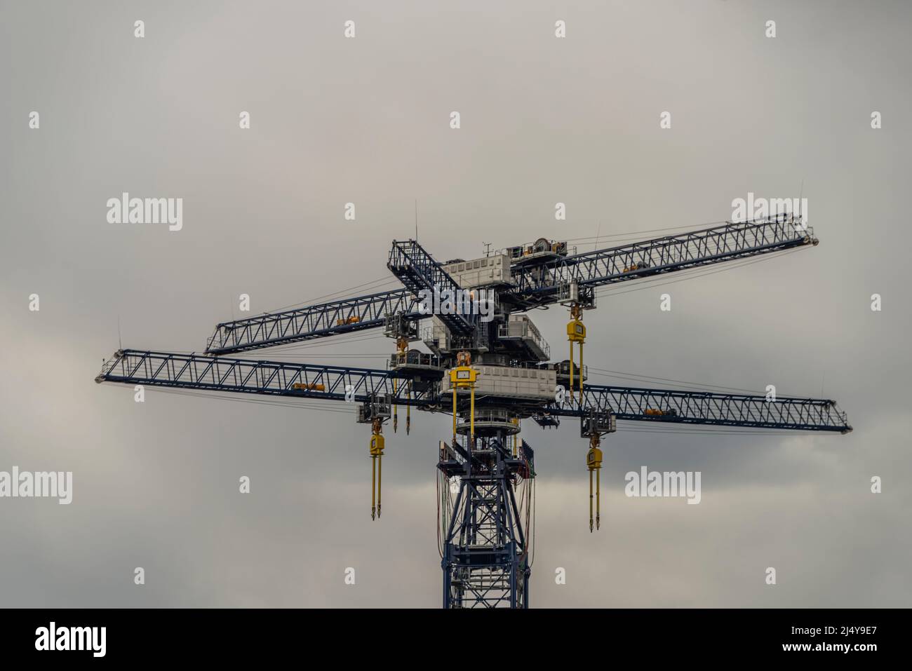 Very big crane with cloudy dark sky background Stock Photo - Alamy
