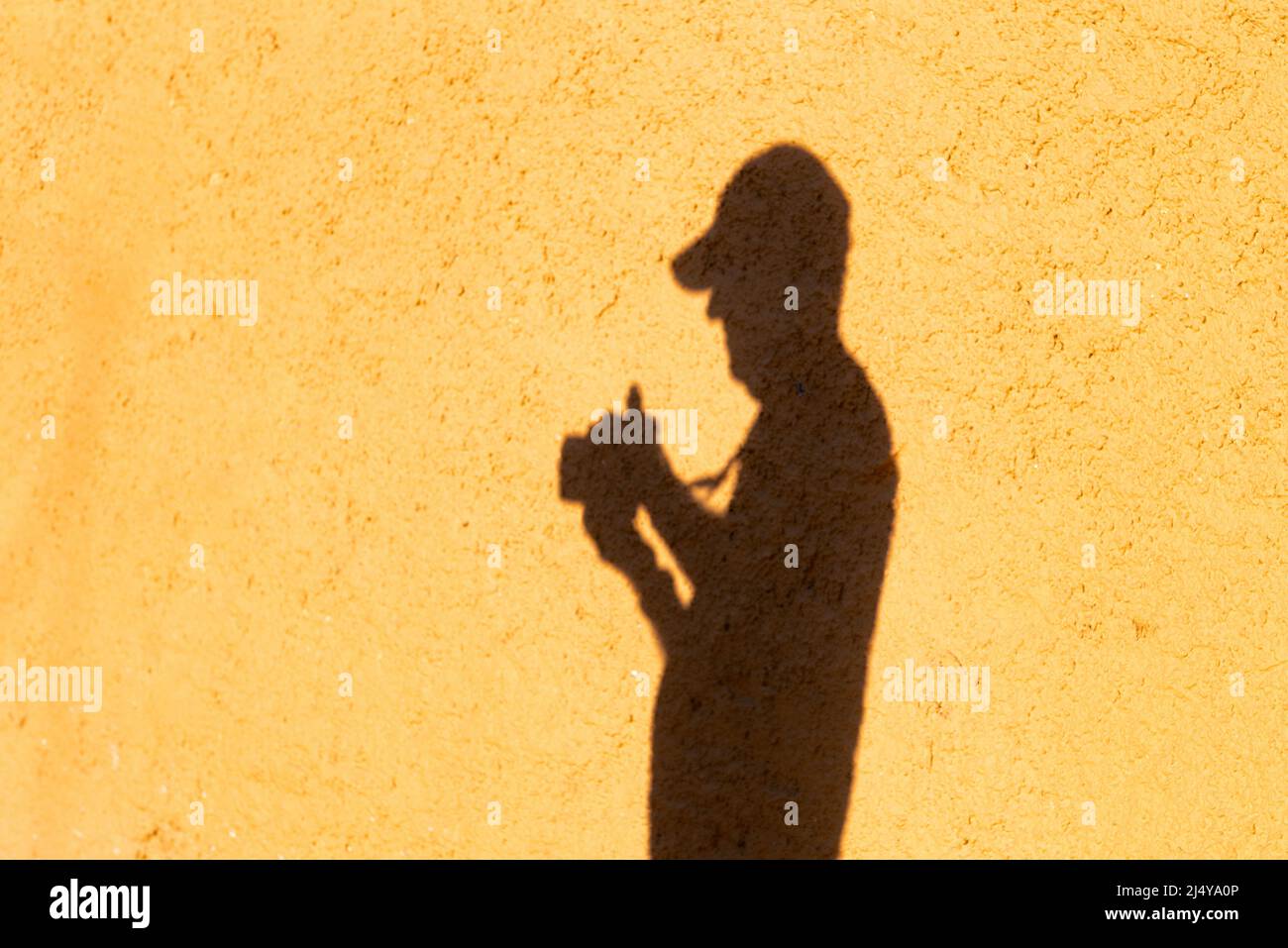 Shadow of a man holding camera Stock Photo - Alamy