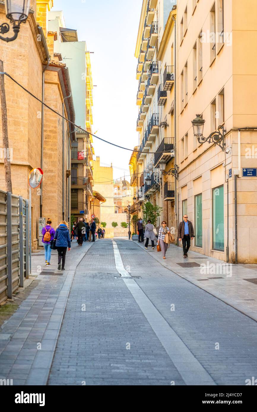Narrow colonial-style street in the old town district. People go their ...