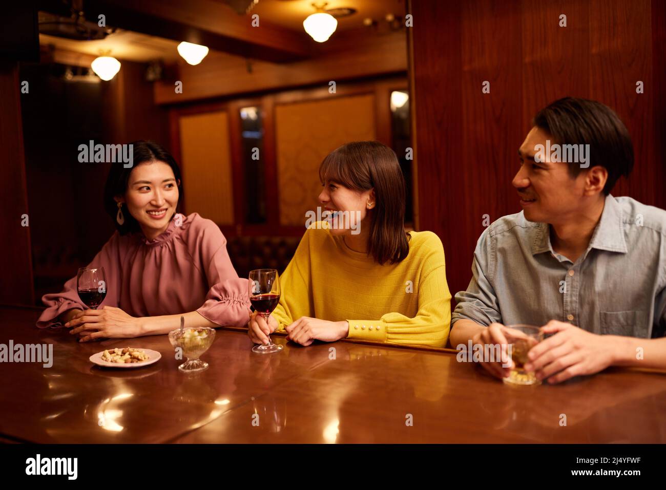 Japanese friends having a drink at a bar counter Stock Photo - Alamy
