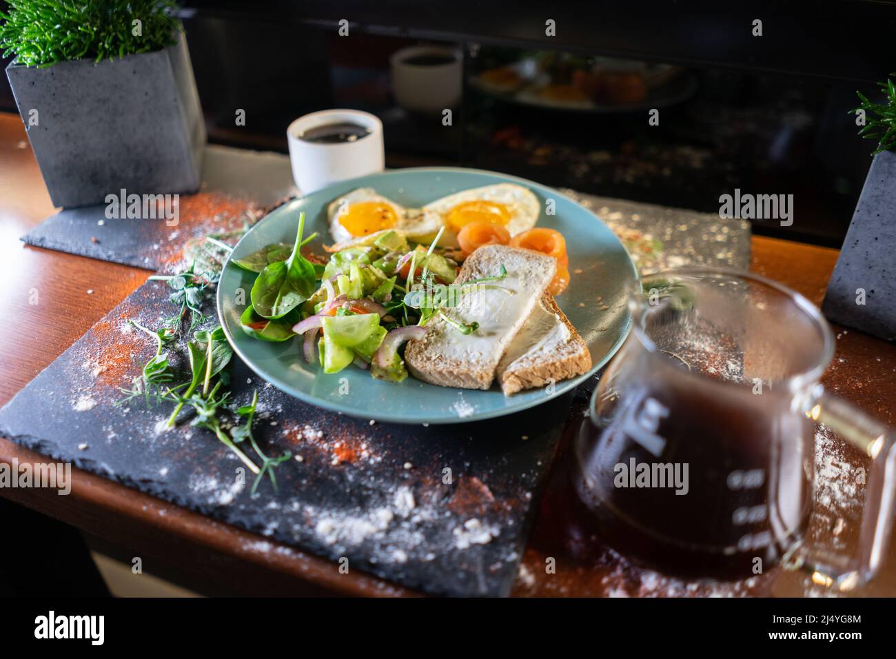 fresh breakfast with fried eggs, bread, avocado, red fish salmon and ...