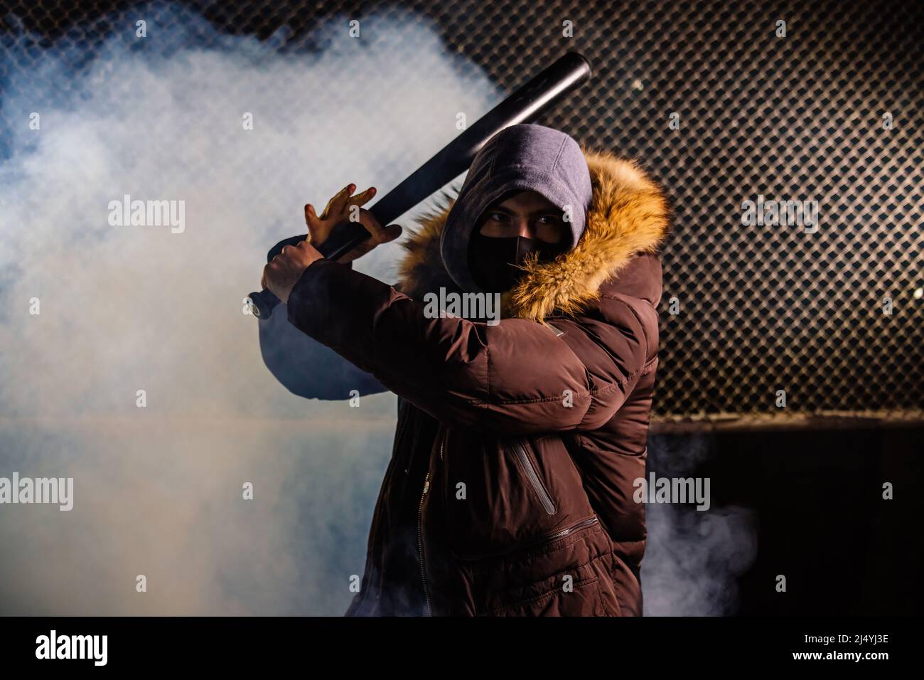 Masked angry man with bat in smoke Stock Photo - Alamy