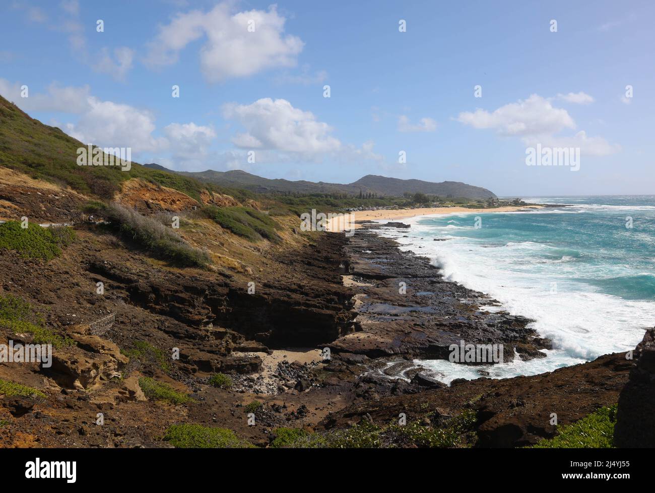 Sweeping beach scene with white waves.cliffs and blue sky Stock Photo ...