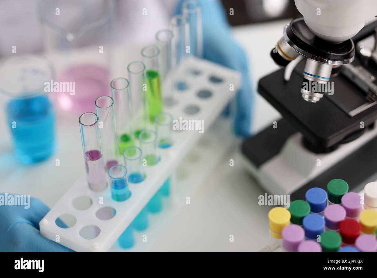 Multicolored laboratory test tubes and microscope in laboratory Stock ...