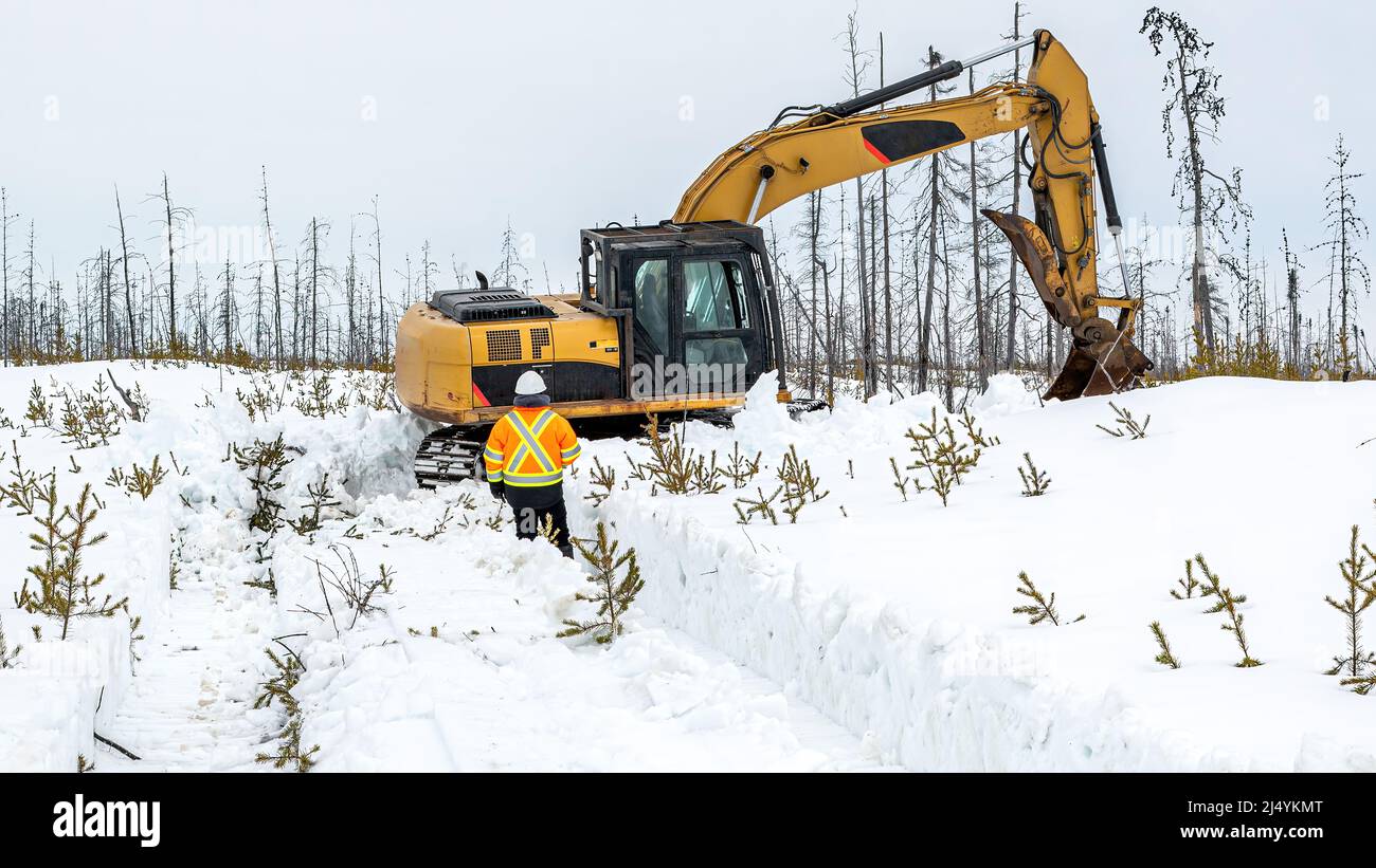 Field work with an excavator in the snow in the northern area of Canada ...