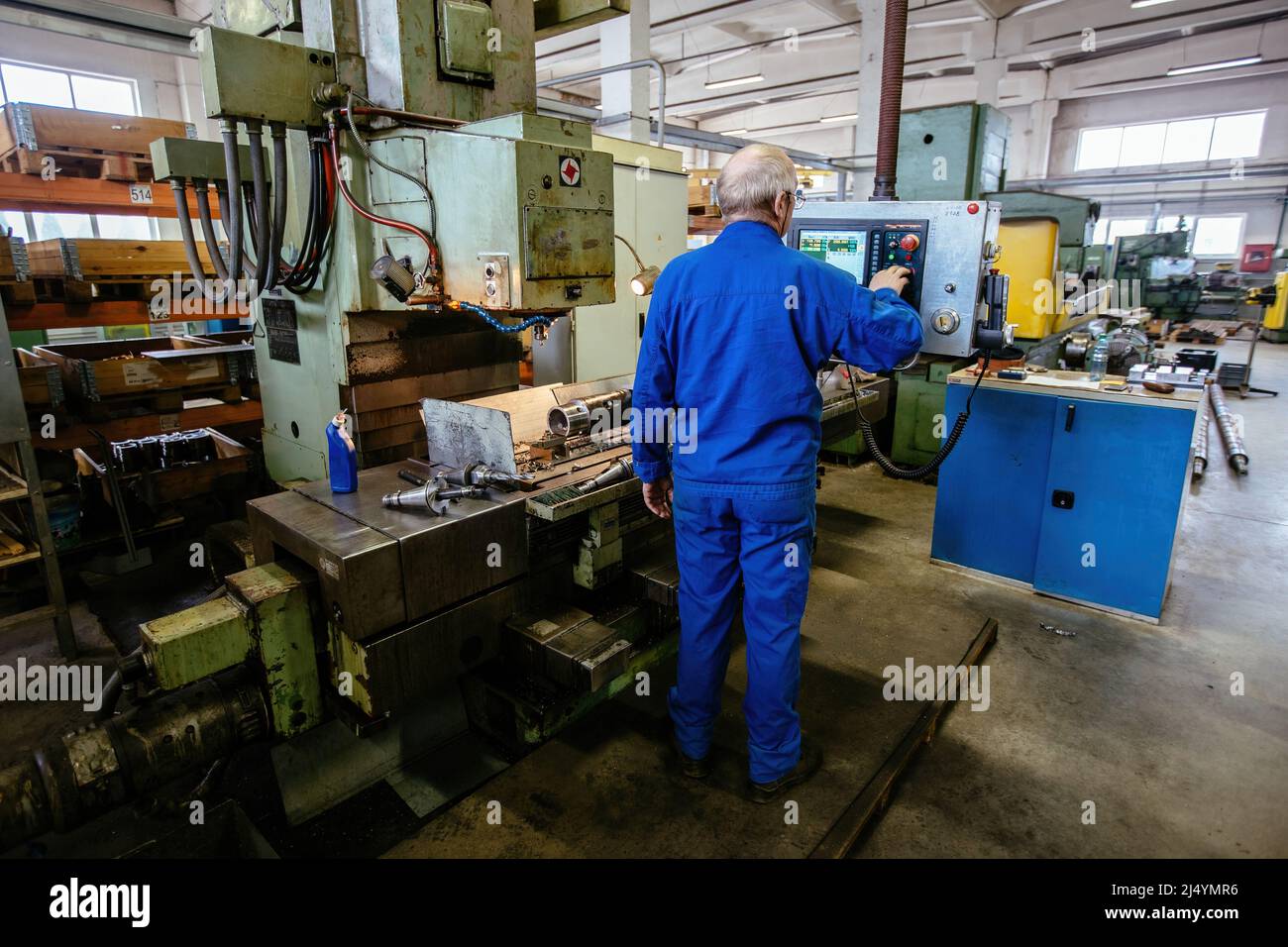 Factory engineer adjusting operation parameters of CNC lathe machine ... Factory engineer adjusting operation parameters of CNC lathe machine ...