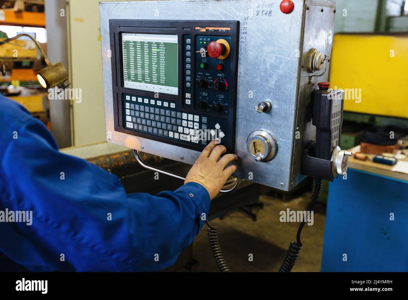 Factory engineer adjusting operation parameters of CNC lathe machine ... Factory engineer adjusting operation parameters of CNC lathe machine ...