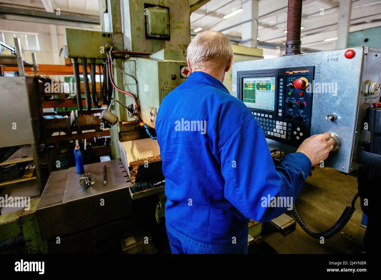 Factory engineer adjusting operation parameters of CNC lathe machine ... Factory engineer adjusting operation parameters of CNC lathe machine ...