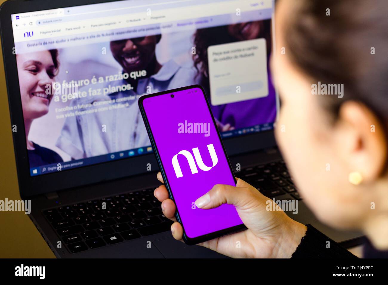 In this photo illustration, a woman holds a smartphone with the Nubank ...
