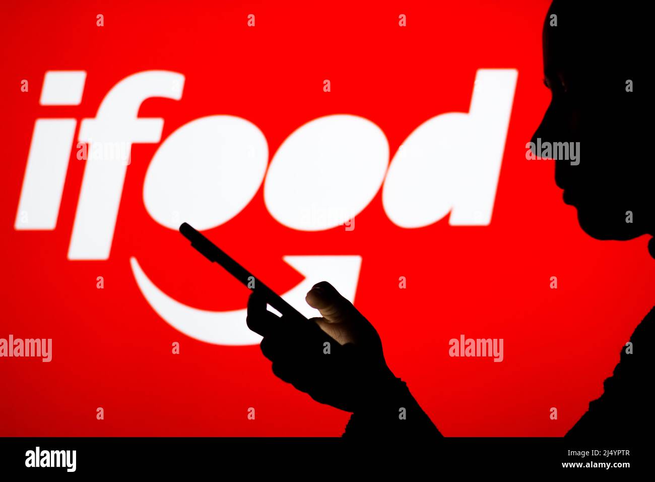 In this photo illustration the iFood logo seen in the background of a ...