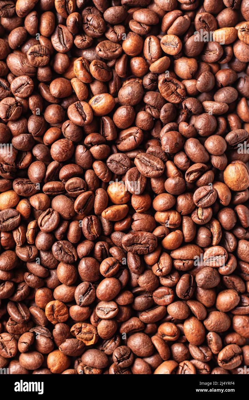 Grains of brown coffee, background texture. Close up. Vertical ...