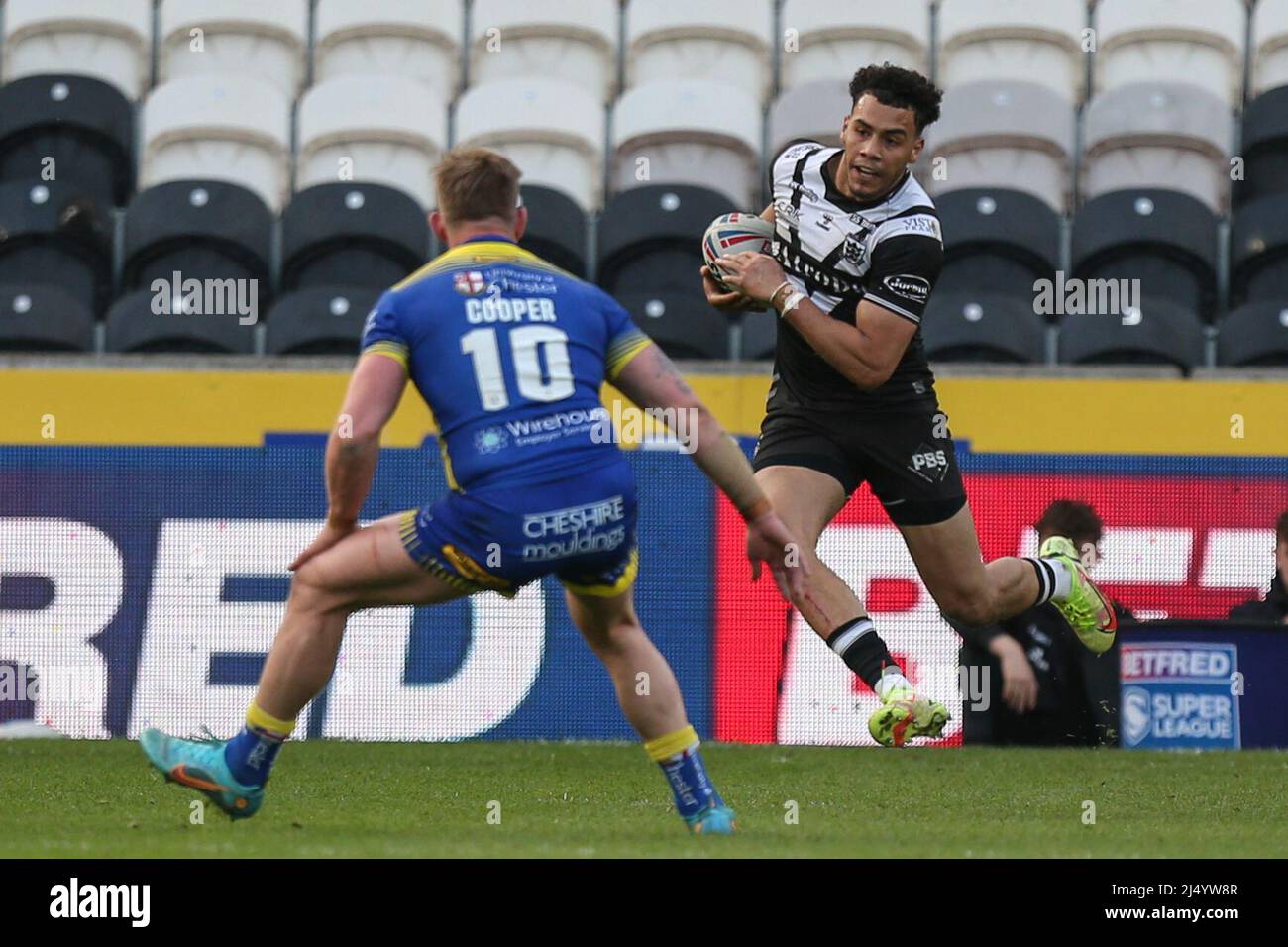 Darnell McIntosh #5 of Hull FC runs at Mike Cooper #10 of Warrington ...