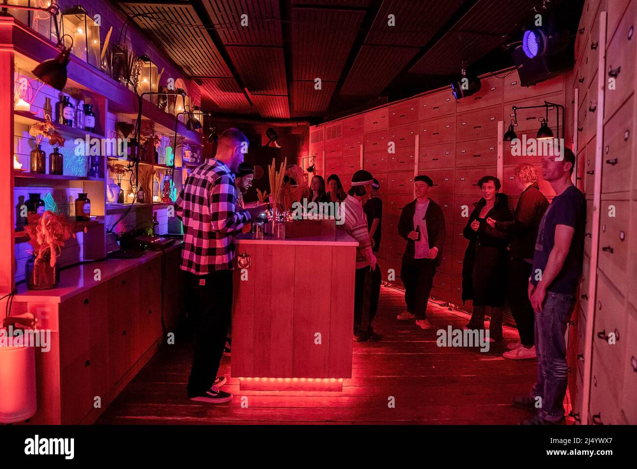 Tourists enjoying drinks at illuminated pub in restaurant during night ...