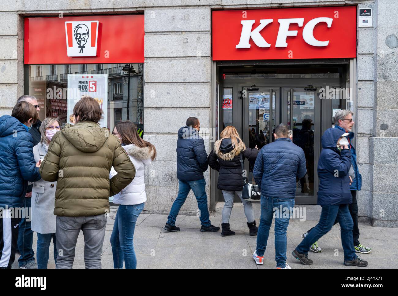 Pedestrians walk past an American fast food chicken restaurant chain ...