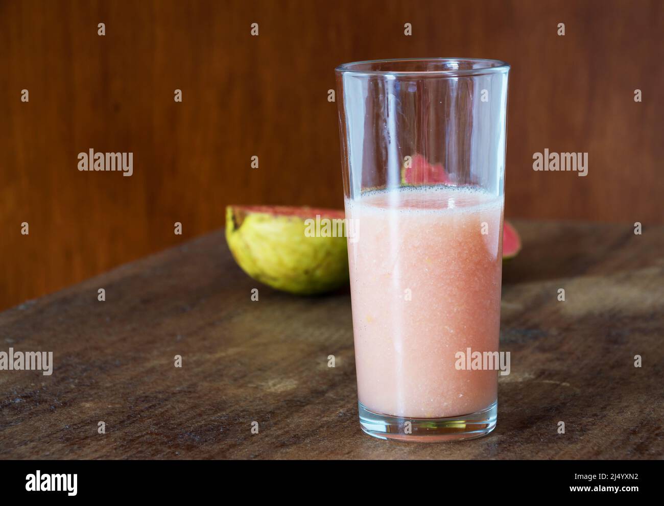 Transparent glass with guava juice and part of split guava in the ...