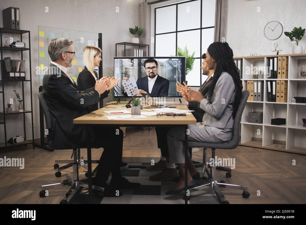 Group of four skillful multiethnical businesspeople clapping hands and ...
