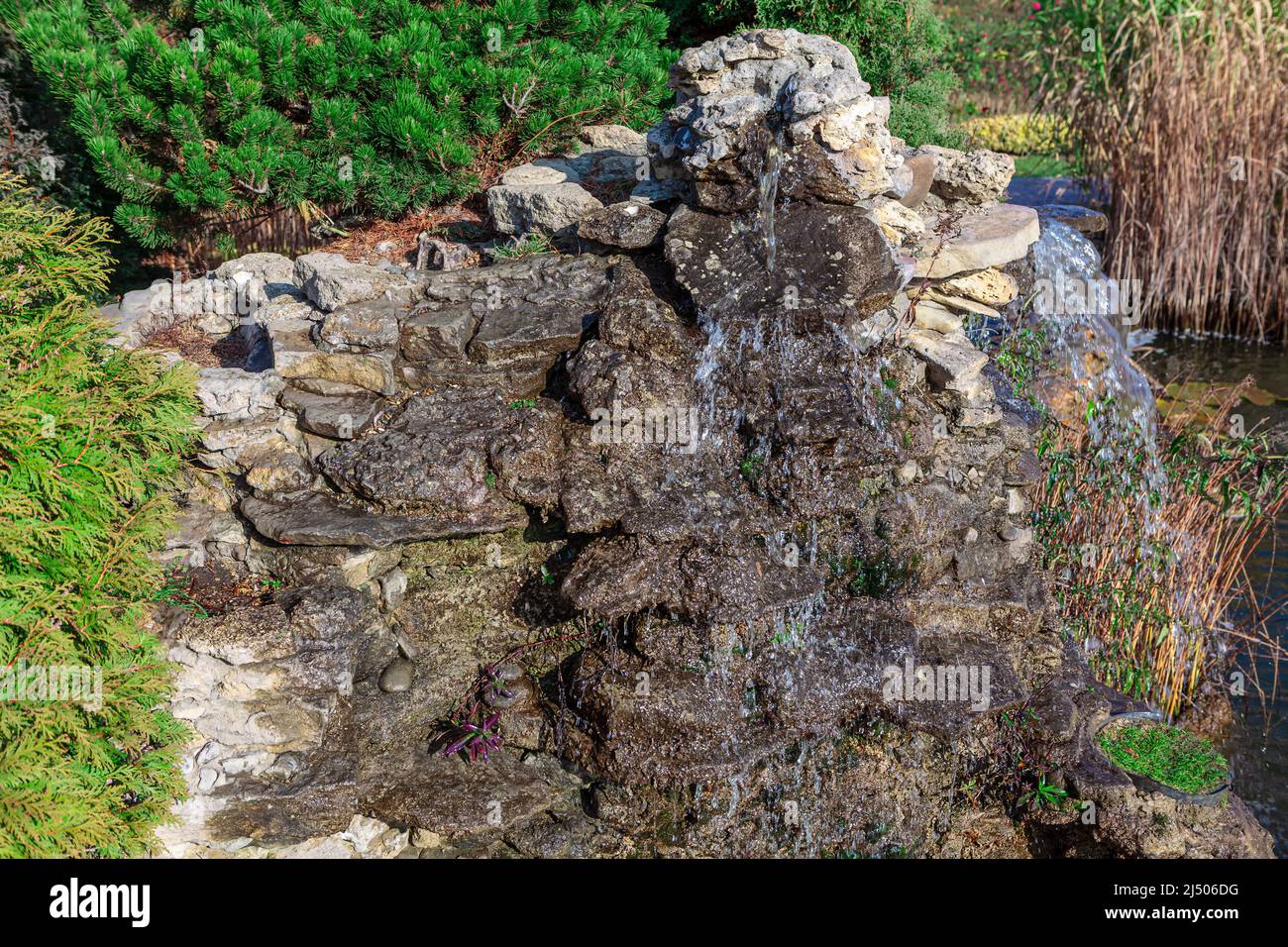 Decorative water cascade in the park . Splashing water over stones ...