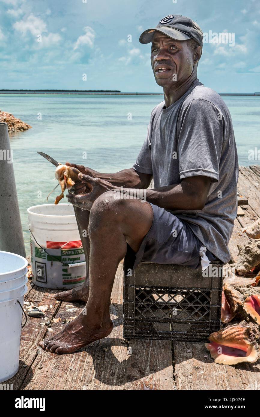 A fisherman dresses conch at native Bahamian seafood restaurant on the ...