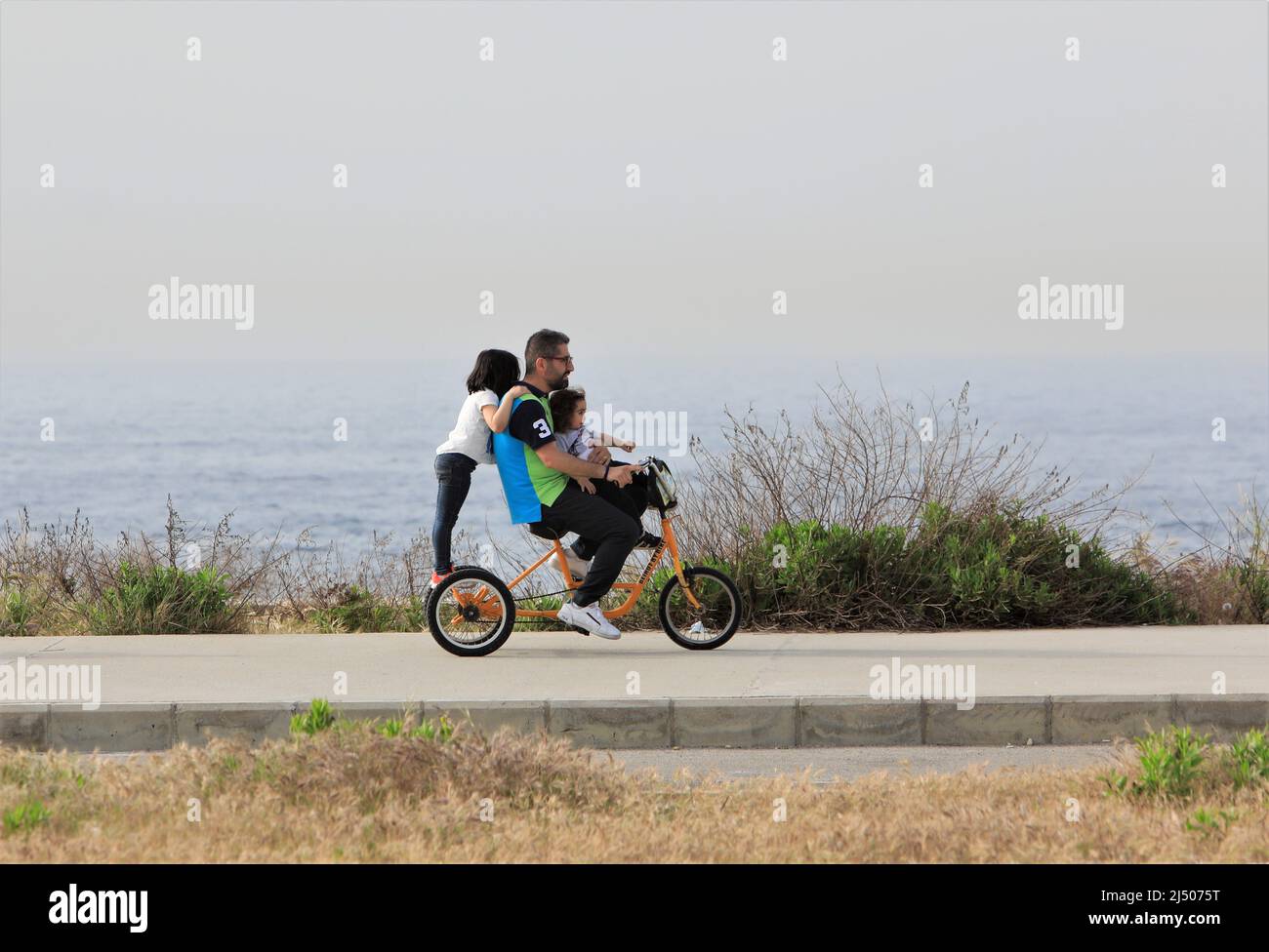 Beirut, Lebanon. 18th Apr, 2022. A man with two children rides a ...