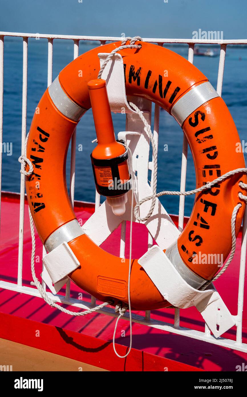 A bright orange life preserver on the deck rail of the Bimini SuperFast ...