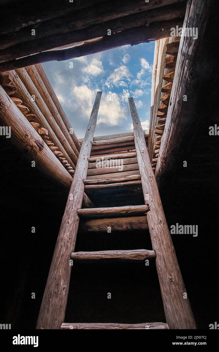 A wooden ladder leads out of the reconstruction of a Native American ...