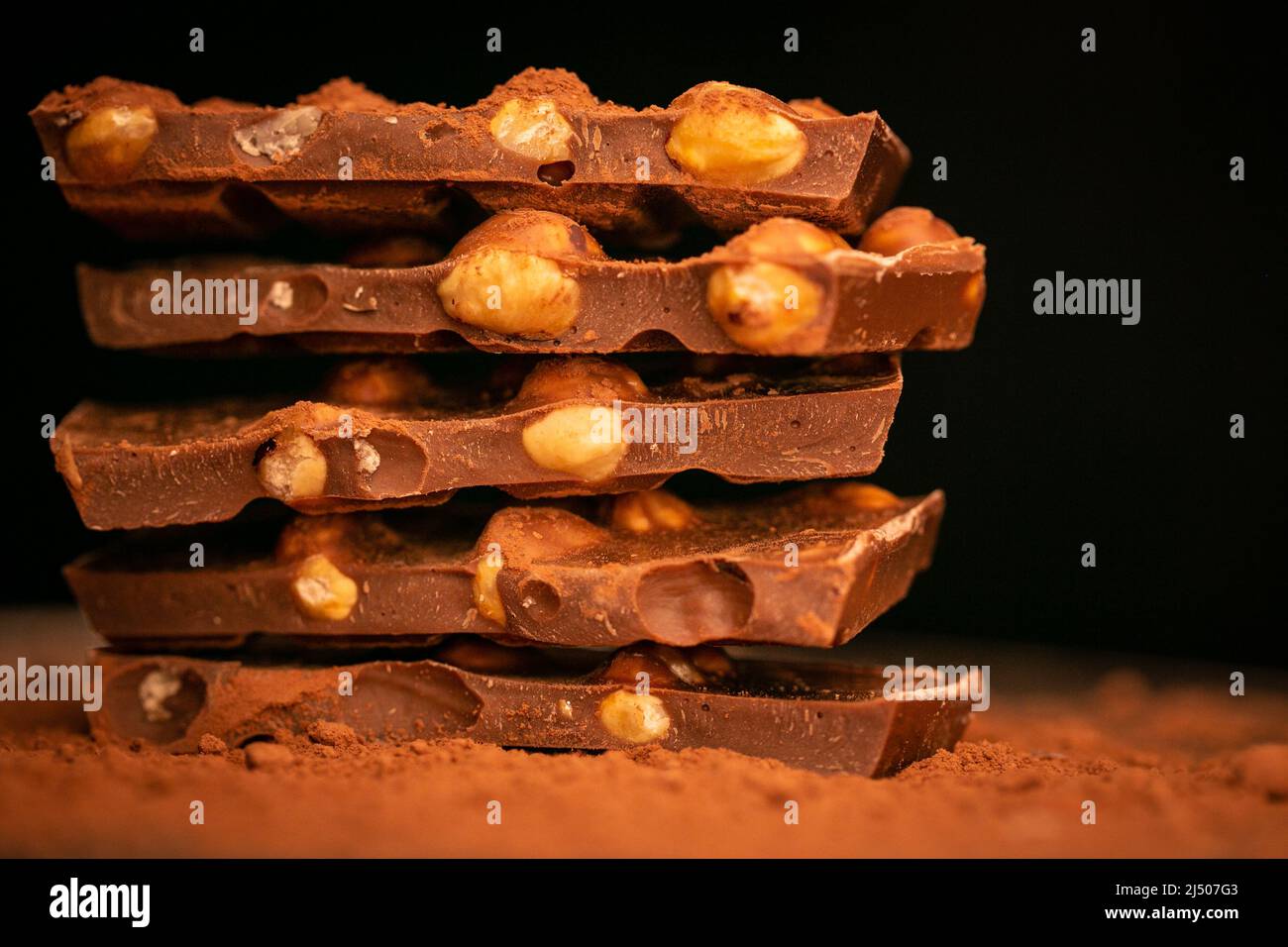 chocolate with nuts stack on a black background.Broken chocolate ...