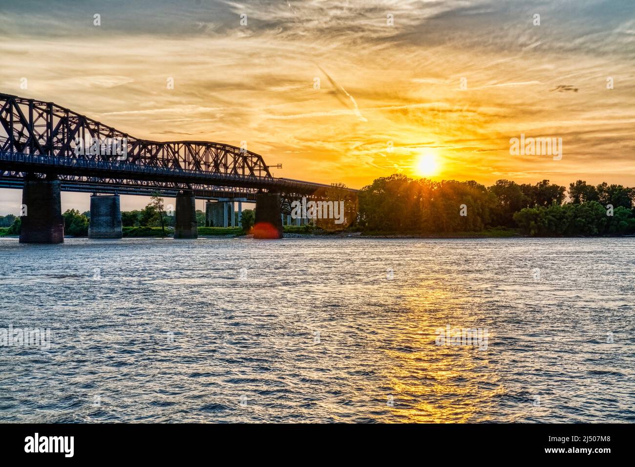 The sun sets over the Arkansas shore by the Harahan Bridge on the ...