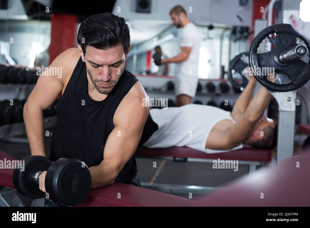 Man exercising with dumbbells in gym Stock Photo - Alamy