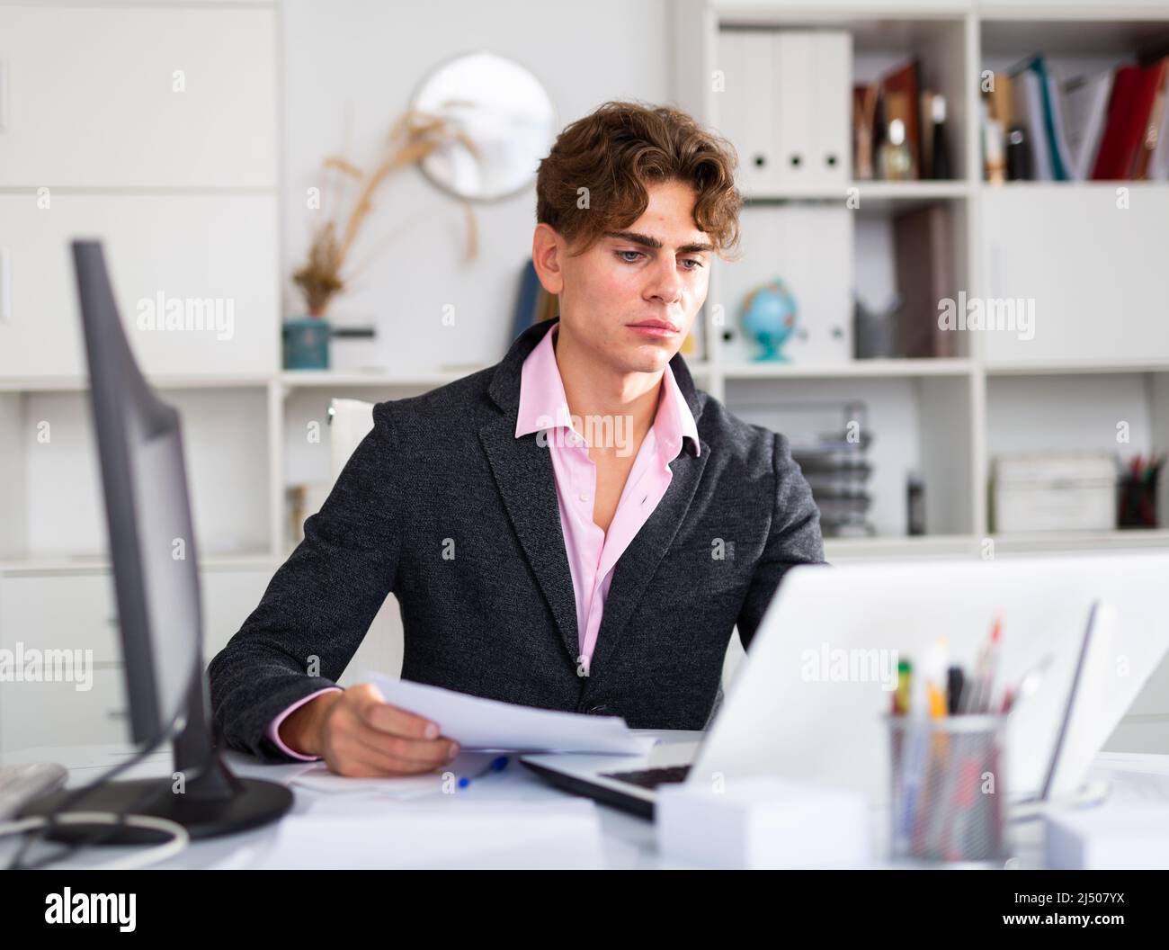 intelligent man working on his laptop in white room Stock Photo - Alamy
